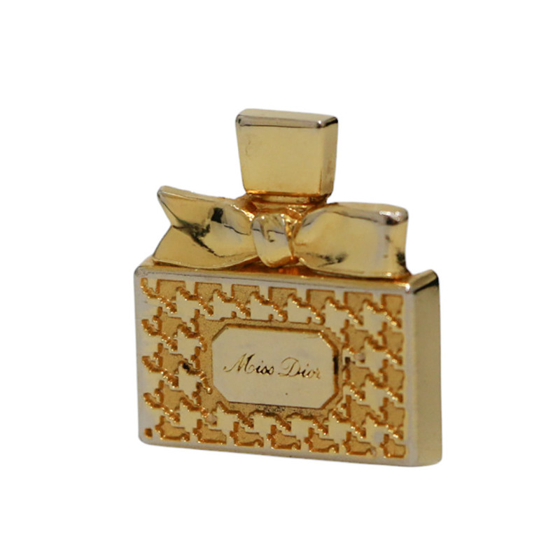Petit pin's miss Dior dorée en forme de bouteille de parfum vintage